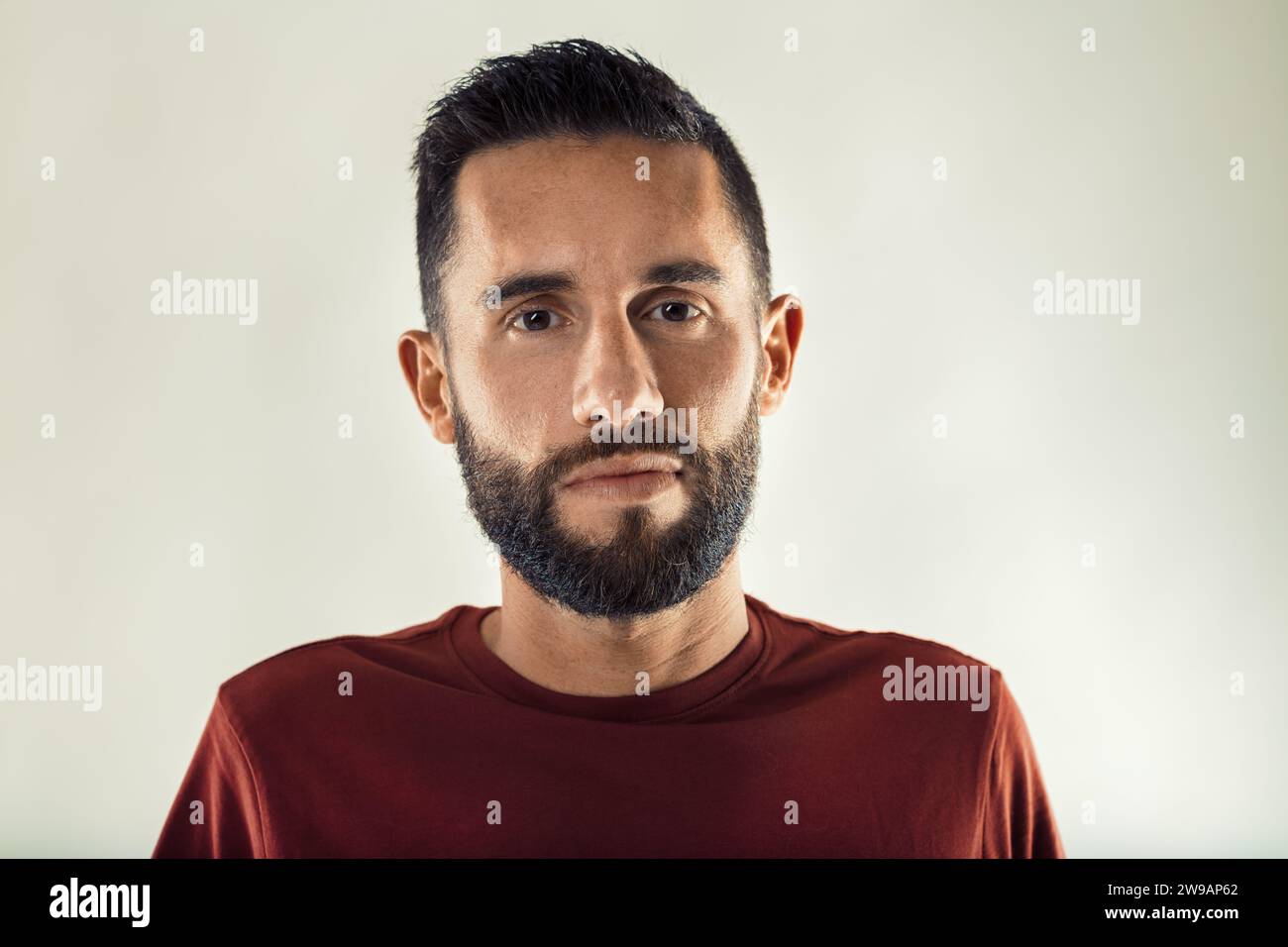 Intense individual with a focused gaze presents a portrait of ...