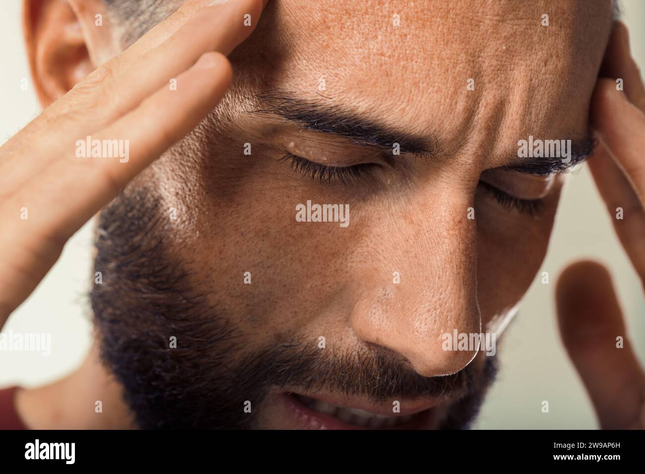 Distressed individual appears to suffer from a headache or intense ...