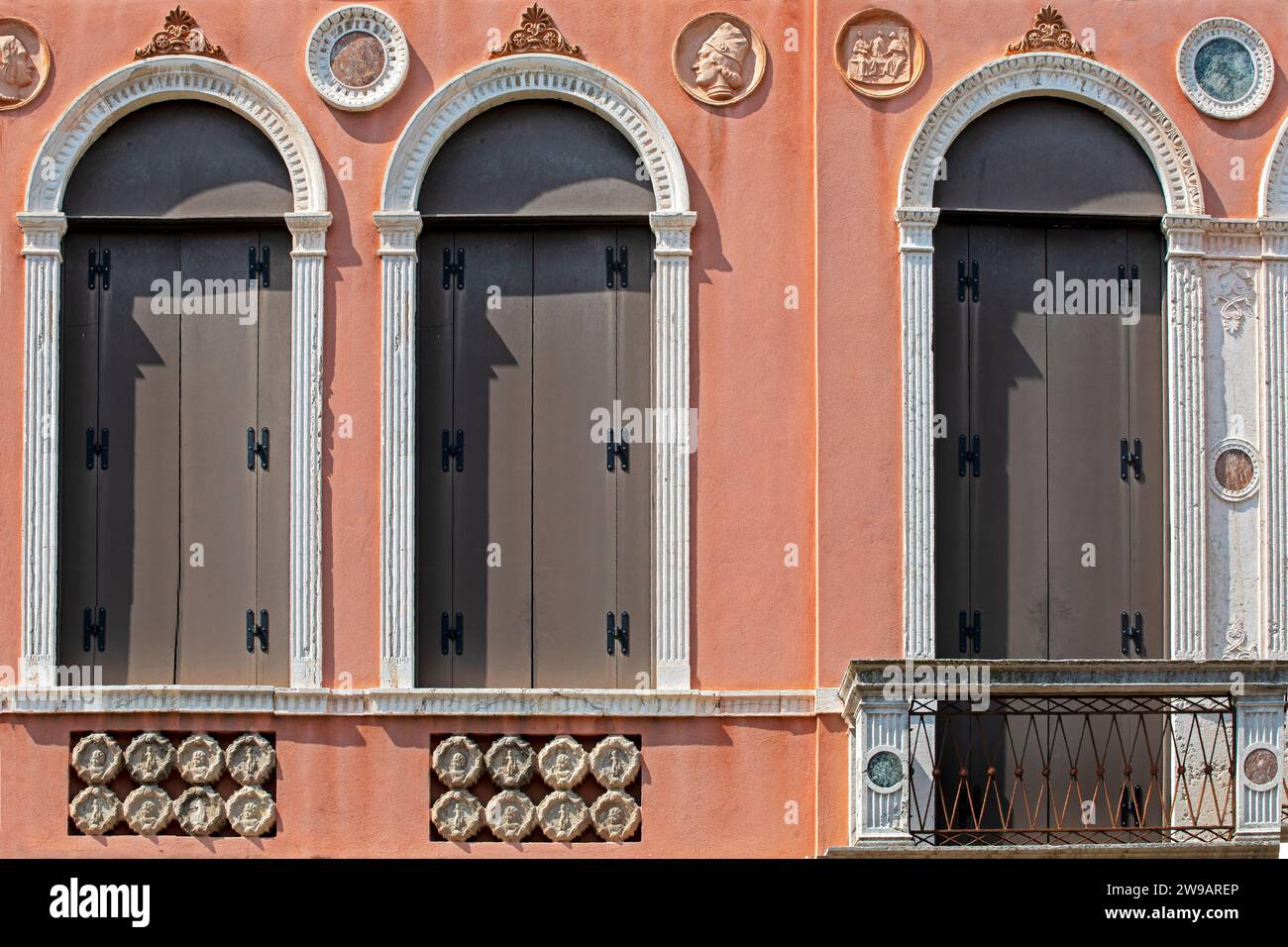 architectural Venetian semicircular windows on the red wall. trip to ...
