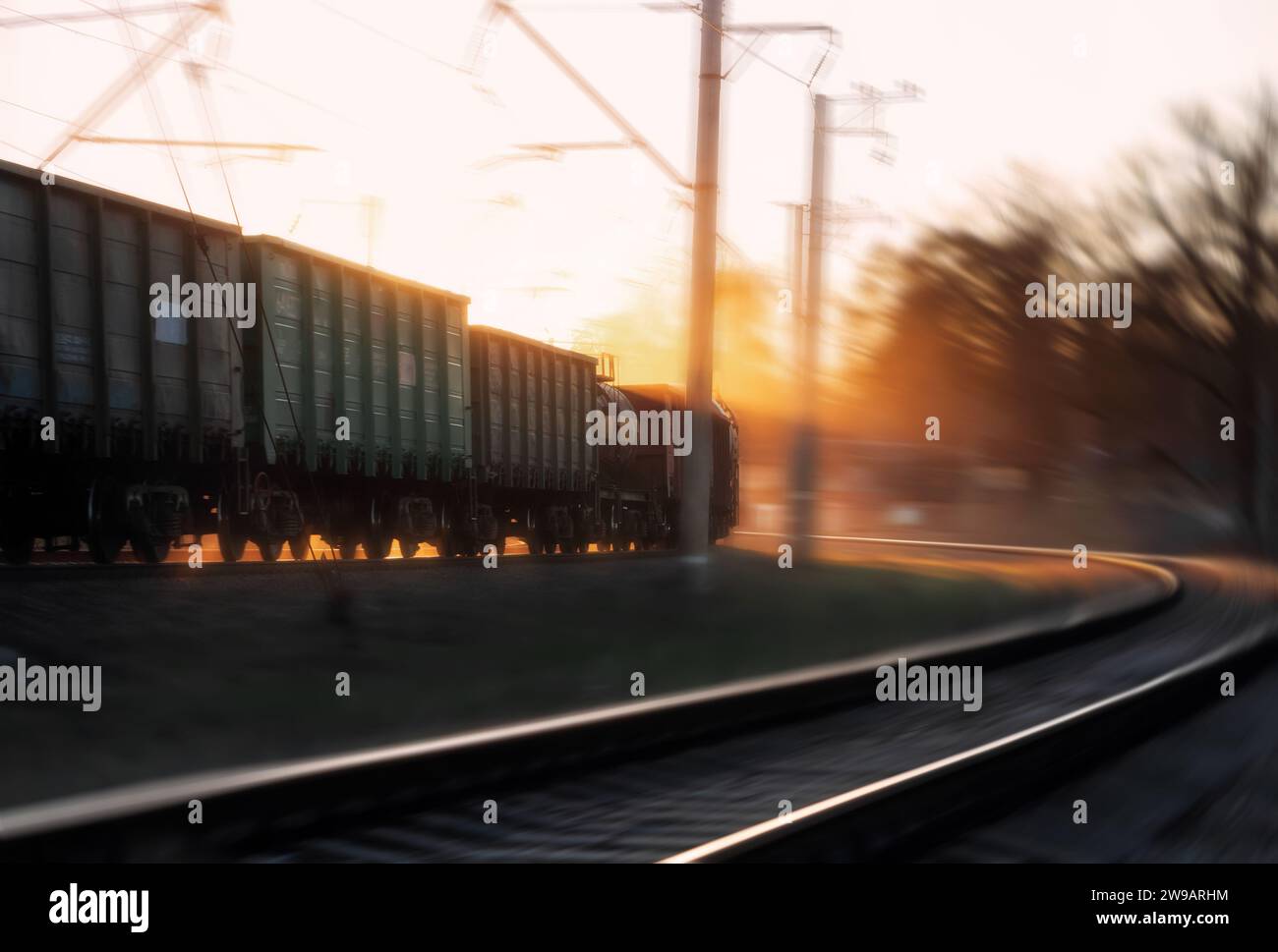 Freight train passing turn at sunset. Train carrying cargo under the ...
