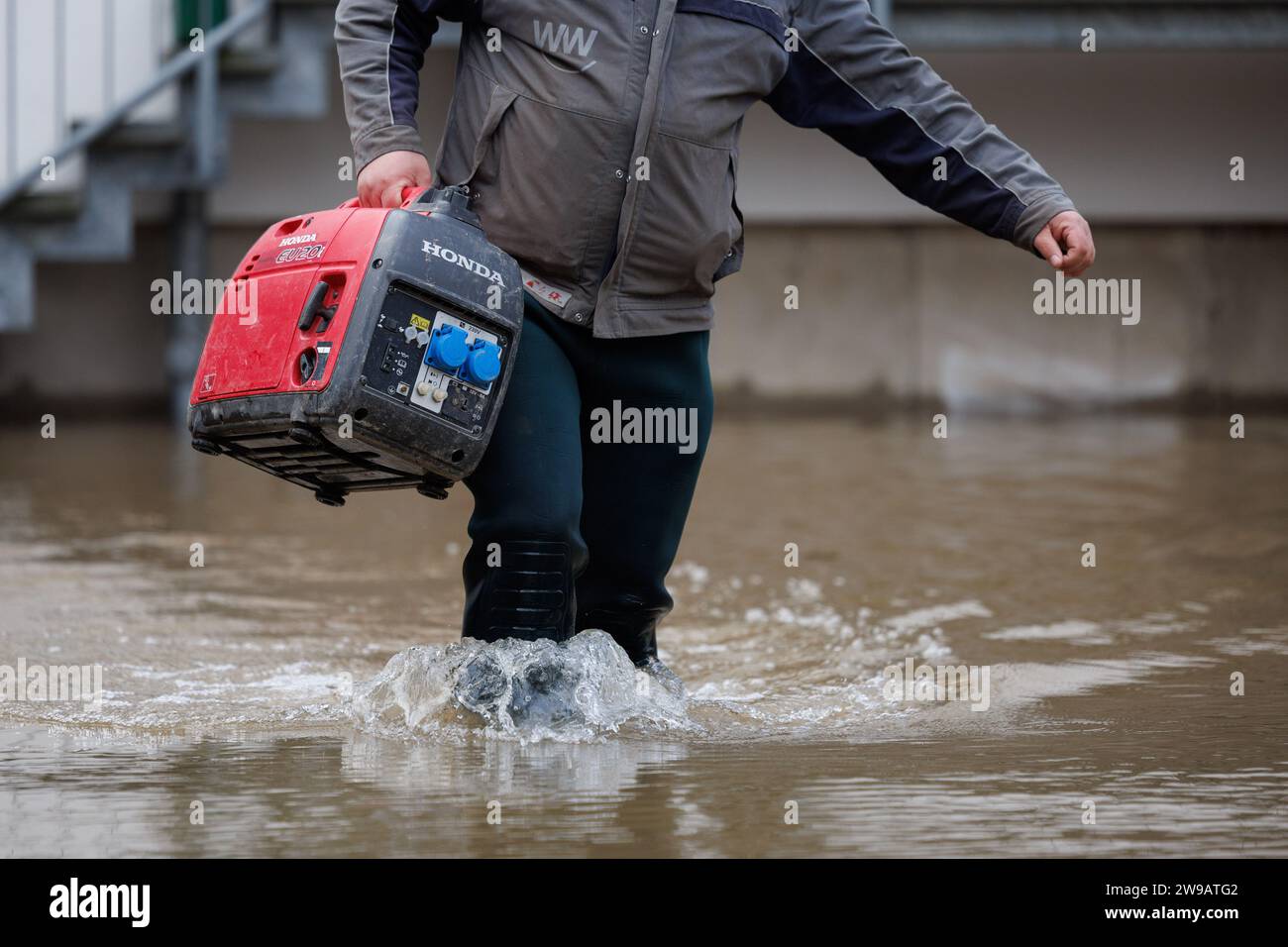 Beverungen, Germany. 26th Dec, 2023. A man carries an electricity ...