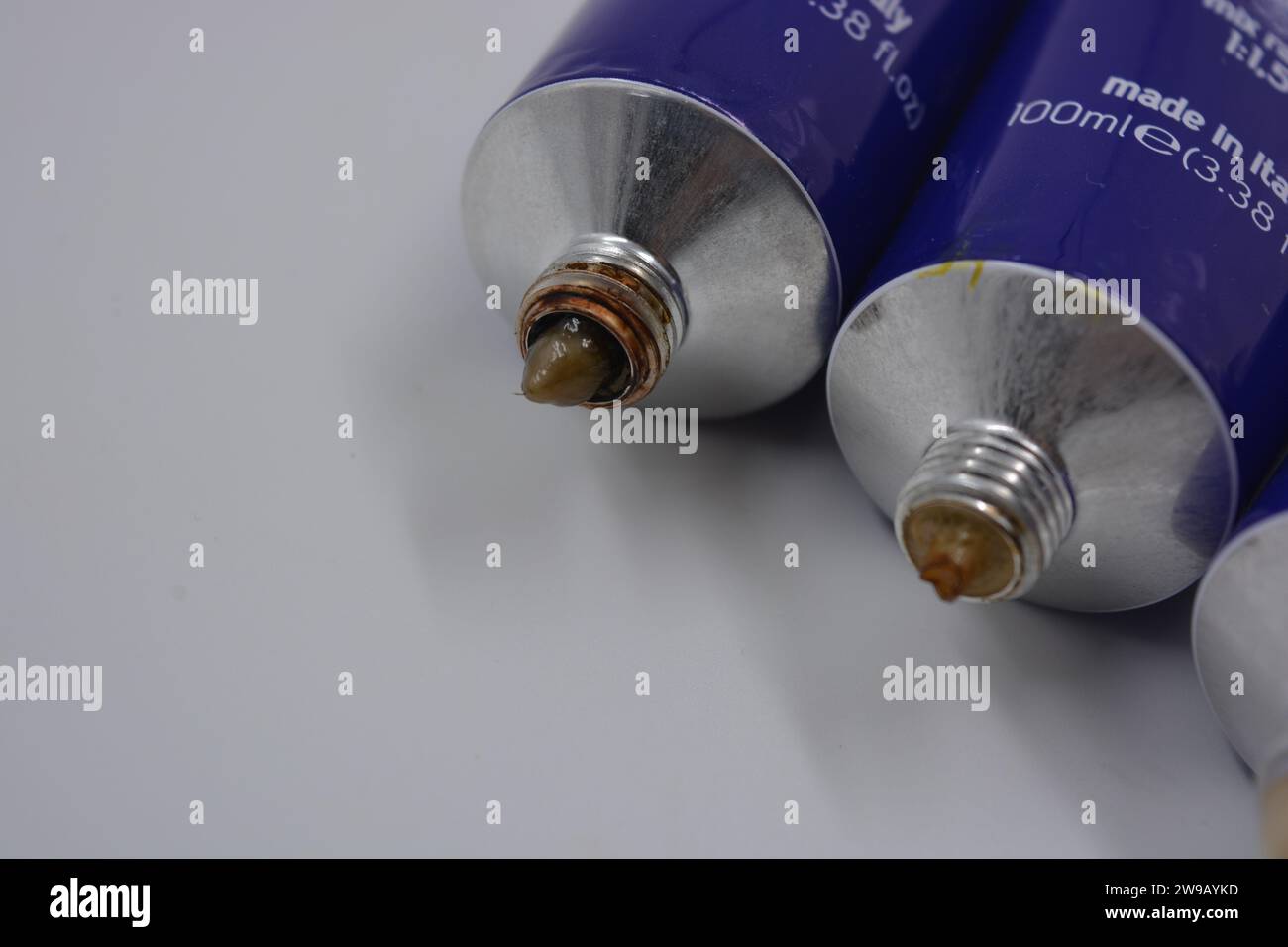 Three metal tubes of women's hair dye with large, clear, plastic lids ...