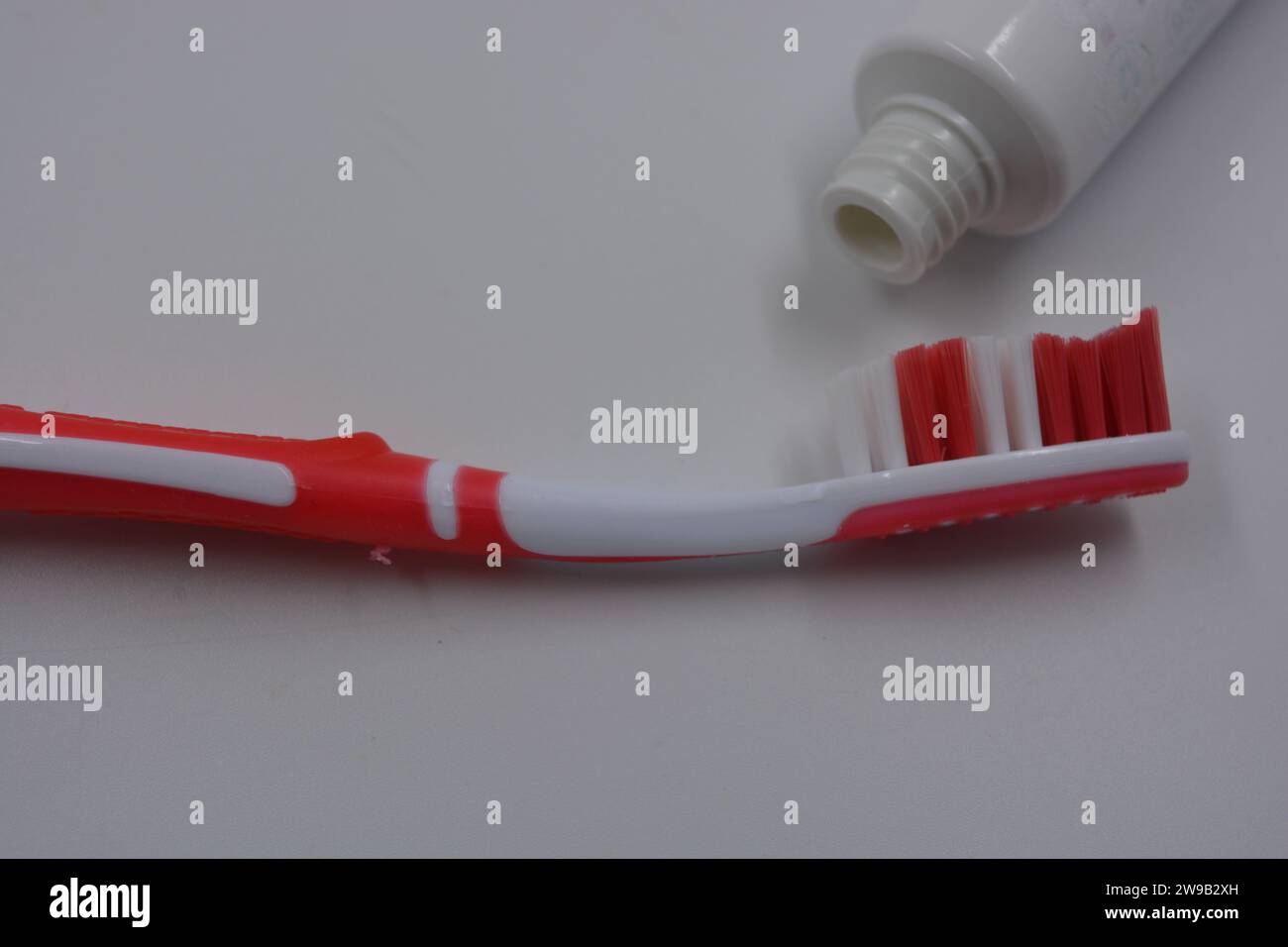 Personal hygiene products, a new plastic toothbrush with red and white ...