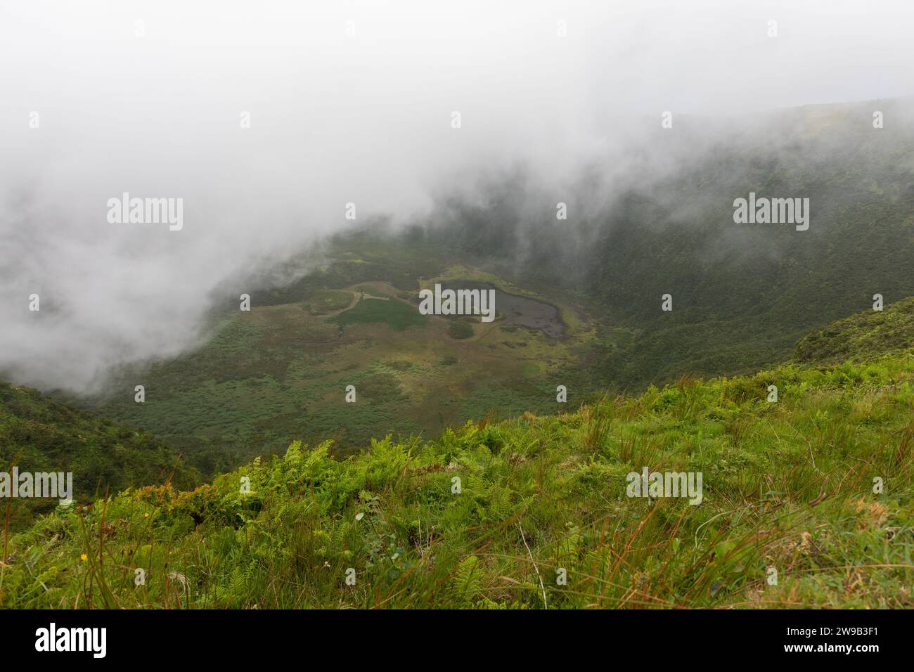 Clouds crawling over the volcanic crater of Caldeira do Faial, Faial ...