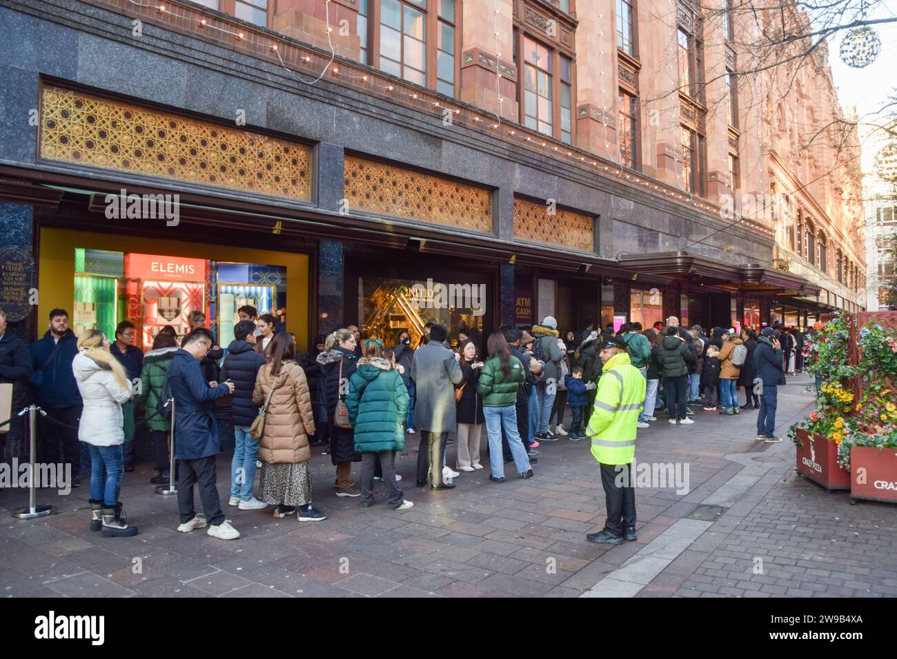 London, UK. 26th Dec, 2023. Customers queue outside Harrods department ...