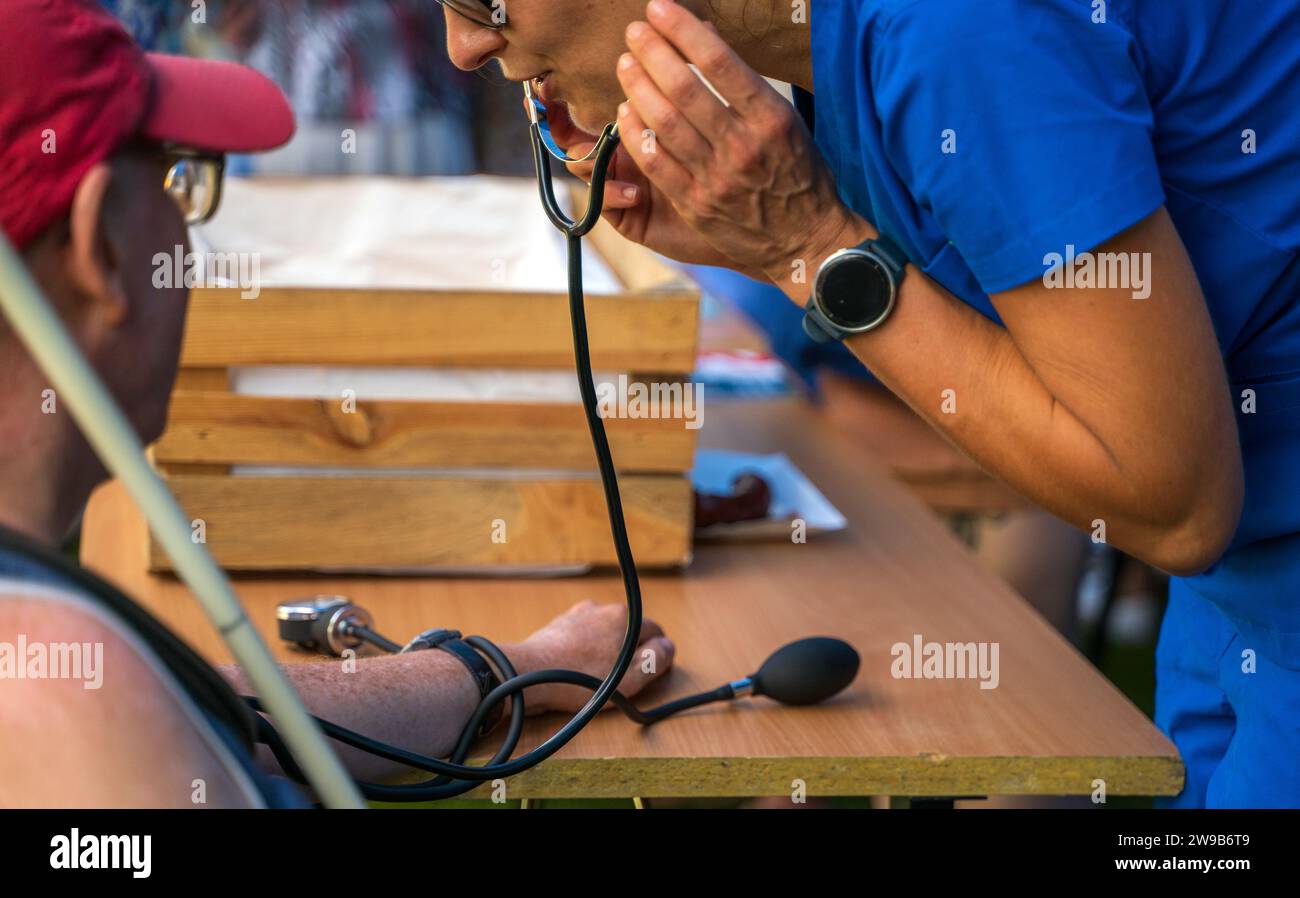 Doctor using sphygmomanometer with stethoscope checking blood pressure ...