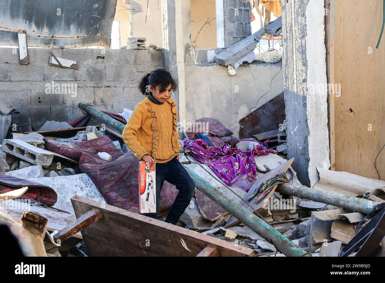 Rafah, Gaza. 26th Dec, 2023. A Palestinians girl walks the rubble of a ...