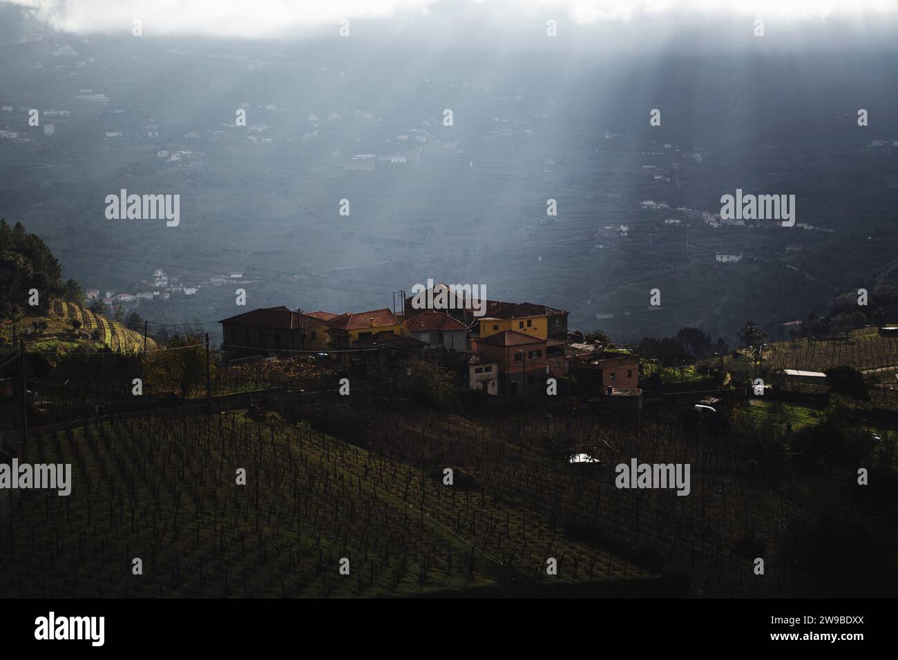 Light through the clouds illuminates a village in the hills of the ...