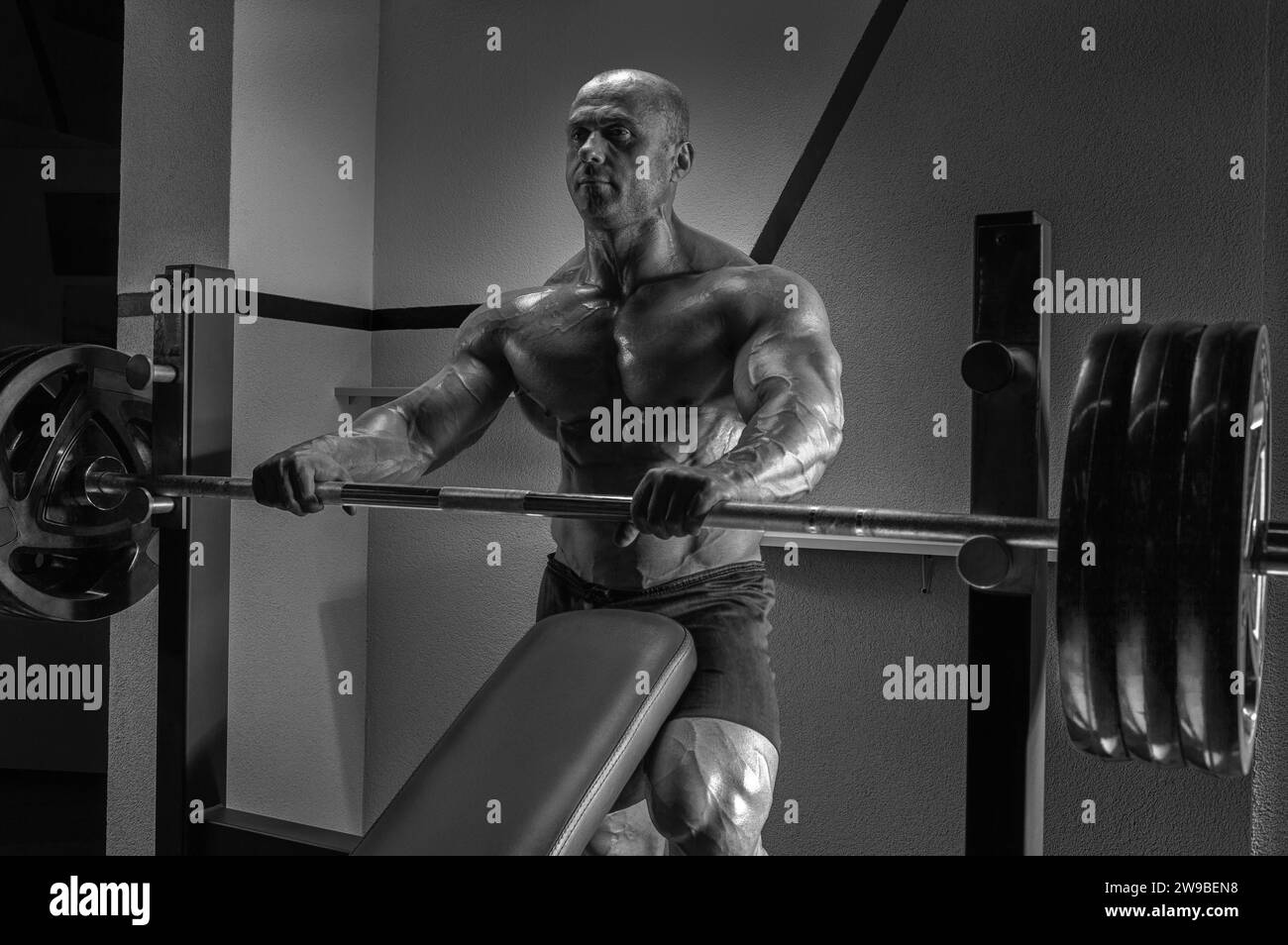 Muscular man stands near the barbell. Bodybuilding concept. Mixed media ...