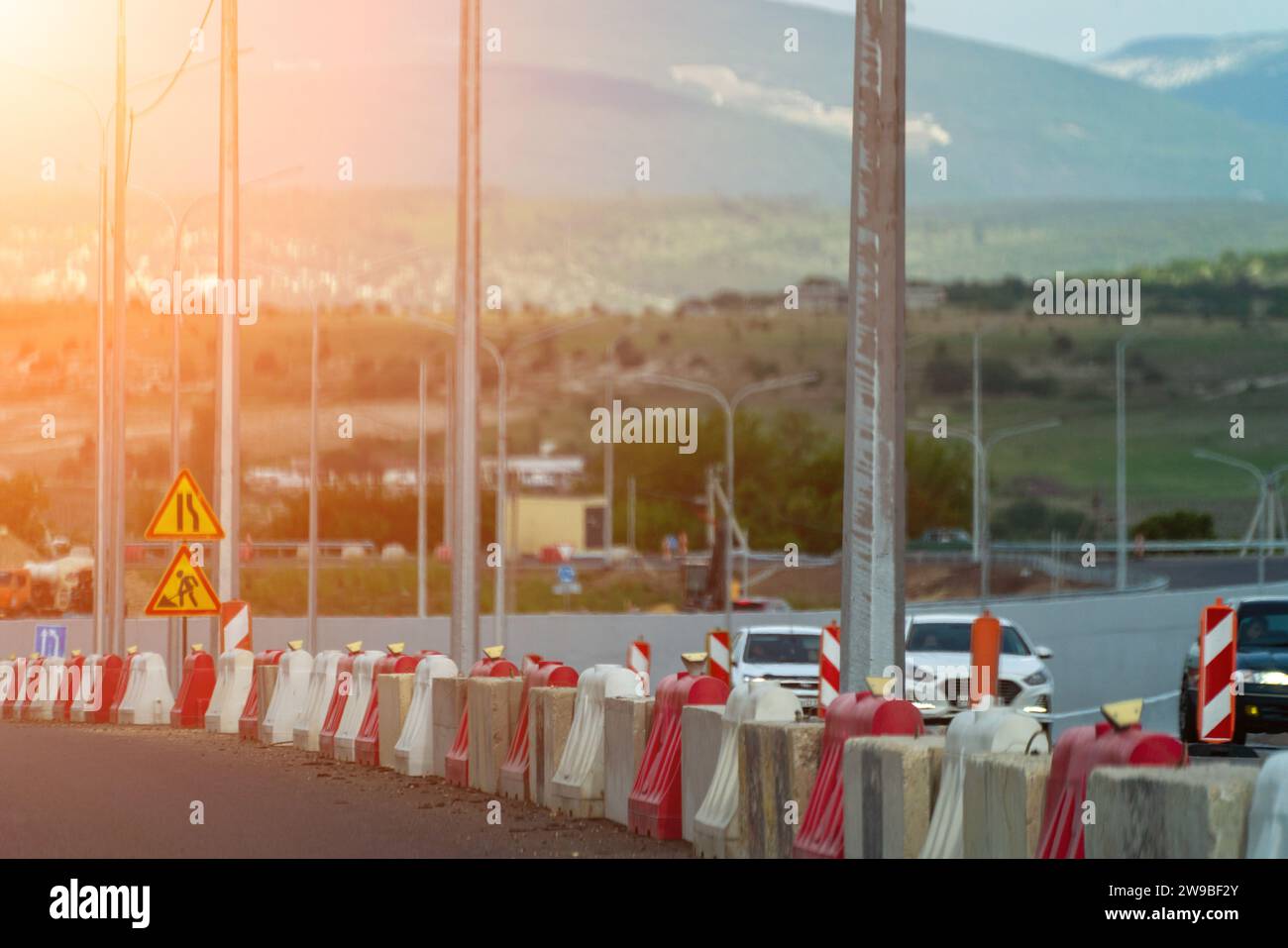 Red, white plastic safety barriers along road. Ensuring road safety ...