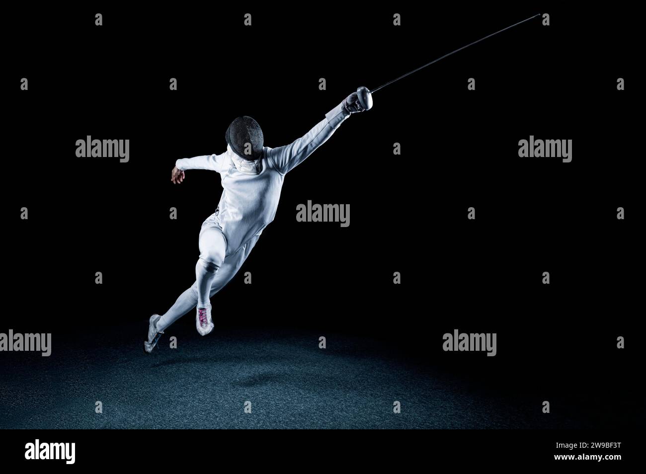 The fencer moves forward with a sword in his hand. Sport concept. Mixed ...