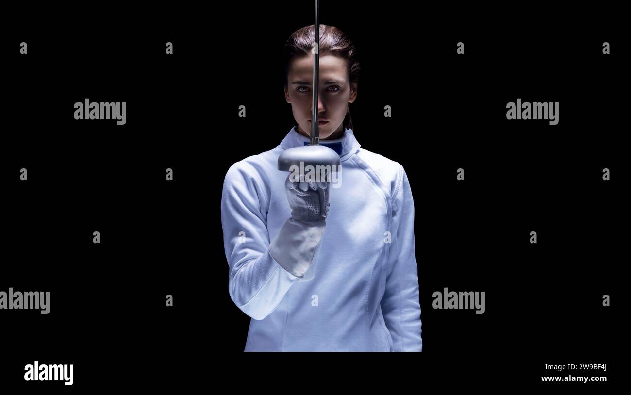 Charming girl in a fencer costume posing on a black background. The ...