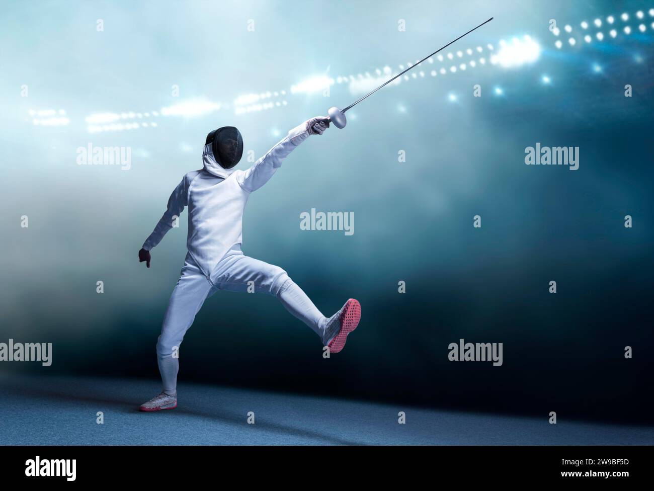 The fencer moves forward with a sword in his hand. Sport concept. Mixed ...