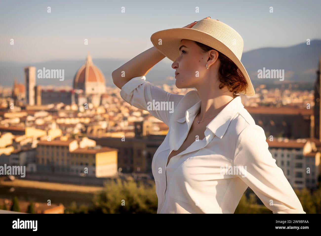 Portrait of a charming girl standing in a square in Florence. View of ...