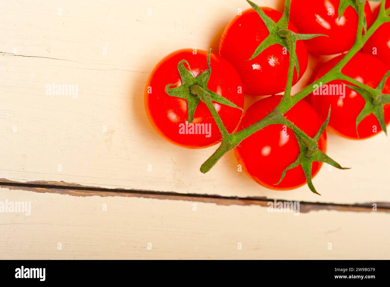 Fresh cherry tomatoes on a cluster over rustic wood table, food ...