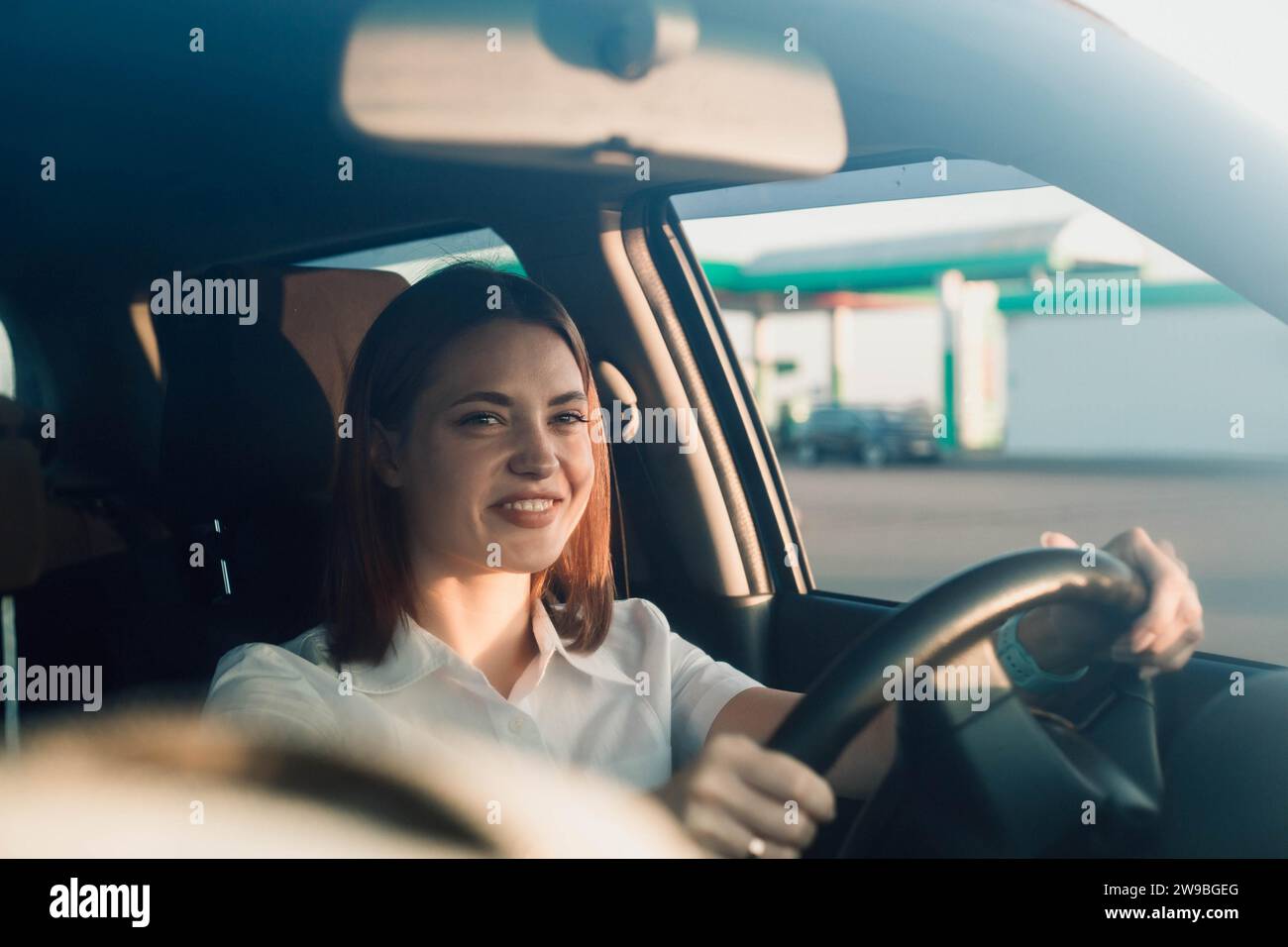 Young beautiful girl taxi driver smiling behind the wheel, friendly ...