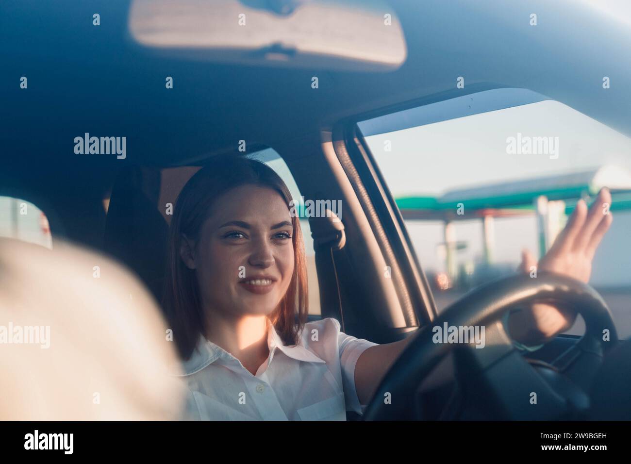 Young beautiful girl taxi driver smiling behind the wheel, friendly ...
