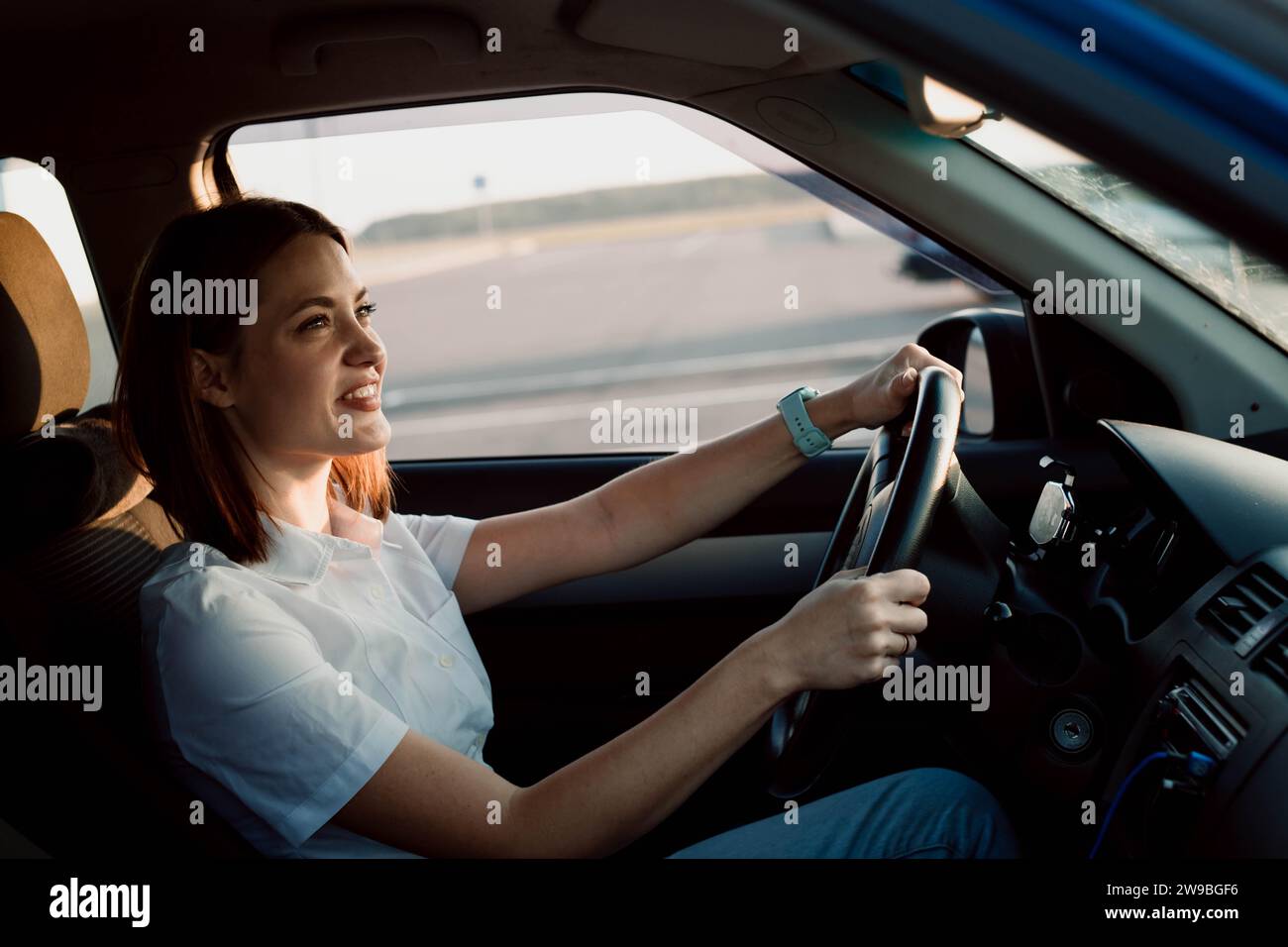 Young beautiful girl taxi driver smiling behind the wheel, friendly ...