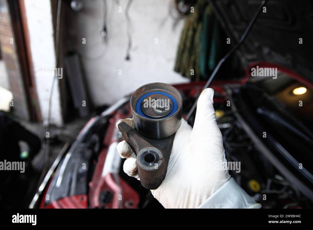 Replacing the tension roller of a car's timing system, mechanic, glove ...