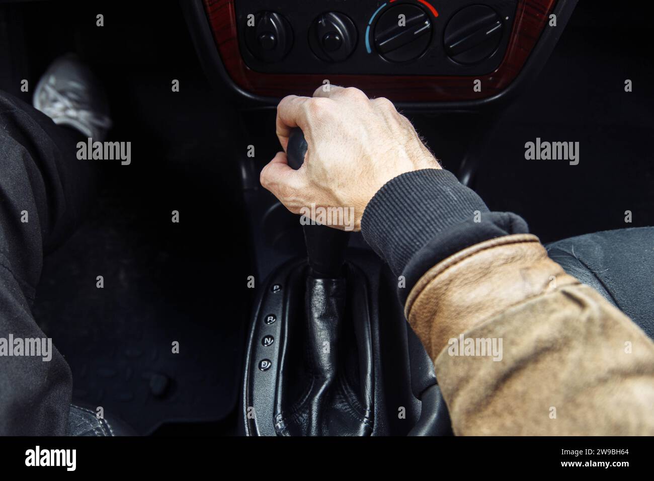 A man is driving a premium car, his hand changes gears on a manual ...