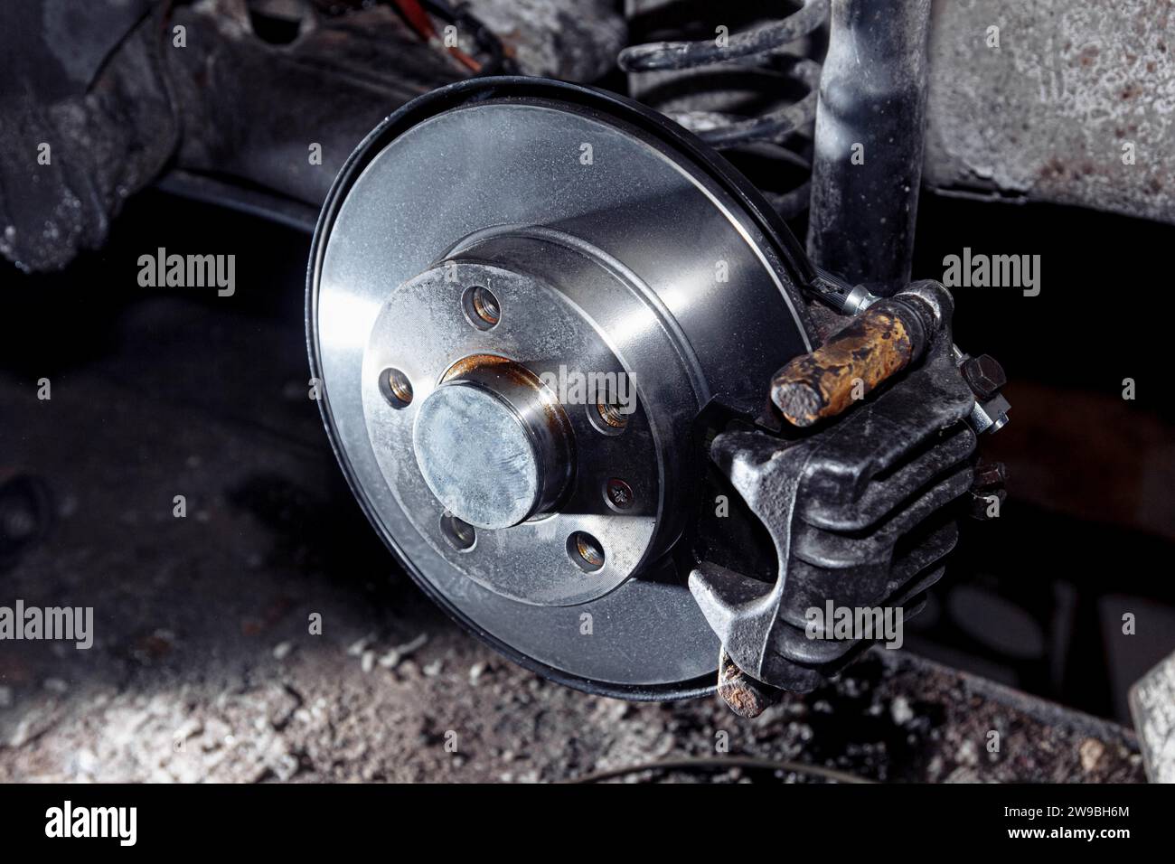 Replacing a brake disc in a car, car repair, mechanic, glove, screws ...