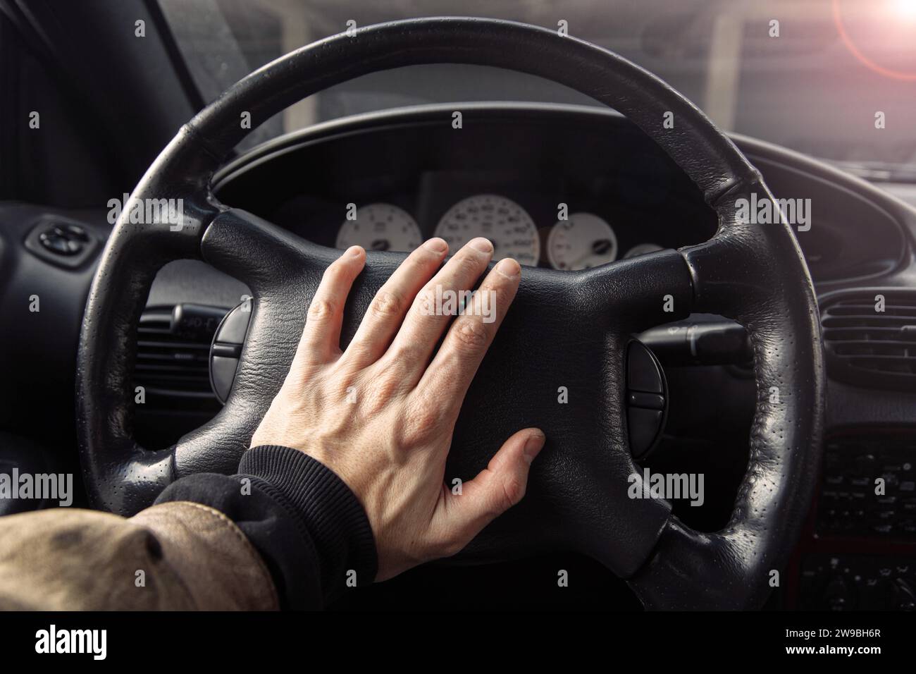 A man is driving a premium car, his hand is on the steering wheel Stock ...