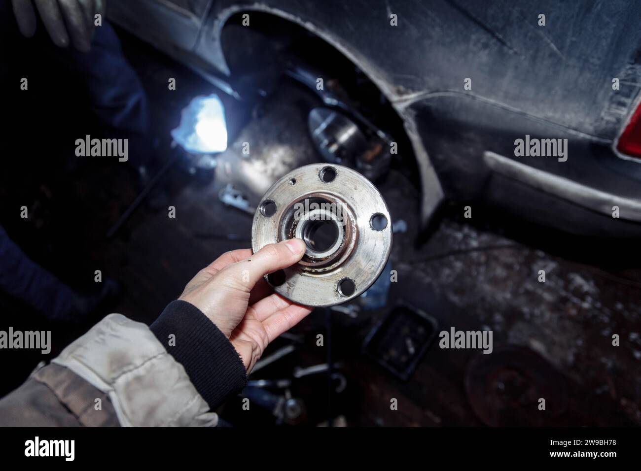 Hub in the hand of an auto mechanic, car repair, mechanic, glove ...