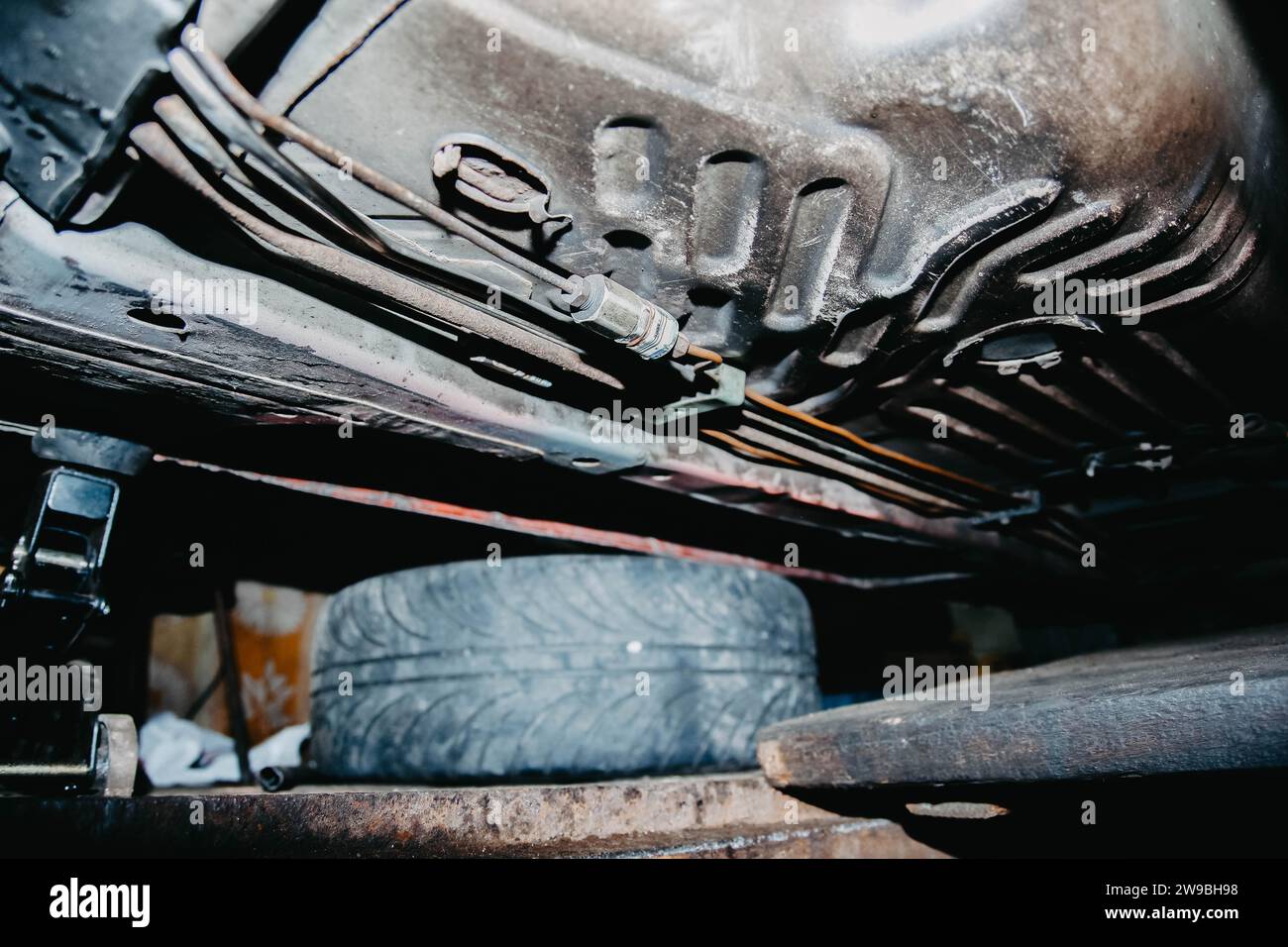 Car bottom close-up, car repair, mechanic, glove, screws, motor ...