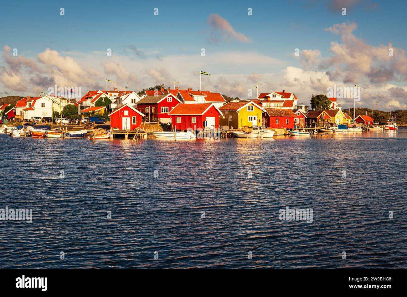 Sunrise over the colourful wooden houses in the harbour of Björholmen ...