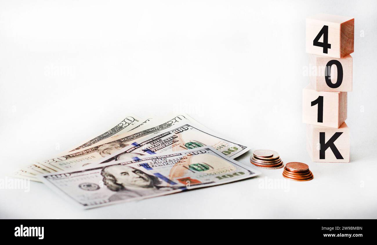 401k words written in wooden cubes on a white background with dollars ...