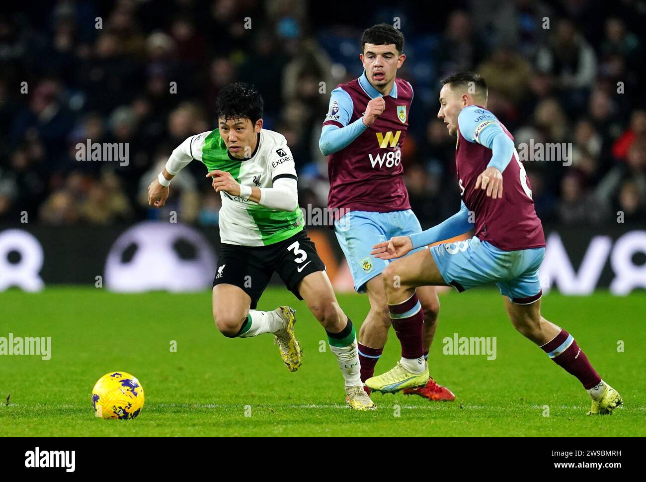 Liverpool's Wataru Endo (left) gets away from Burnley's Josh Brownhill ...