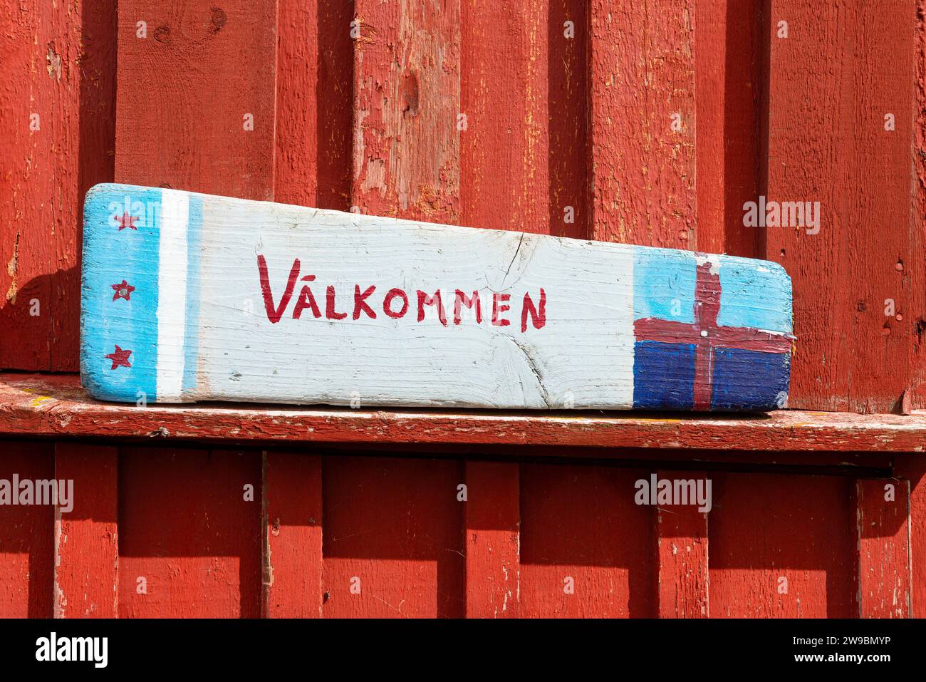Painted wood with lettering 'Welcome', stars and a flag in front of a ...