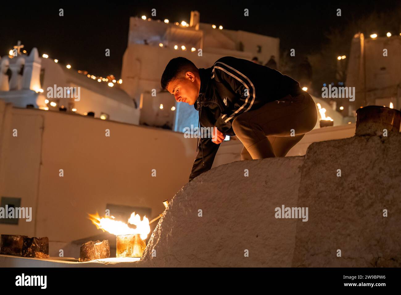 A young man lights up one of the thousands of lanterns for the custom ...