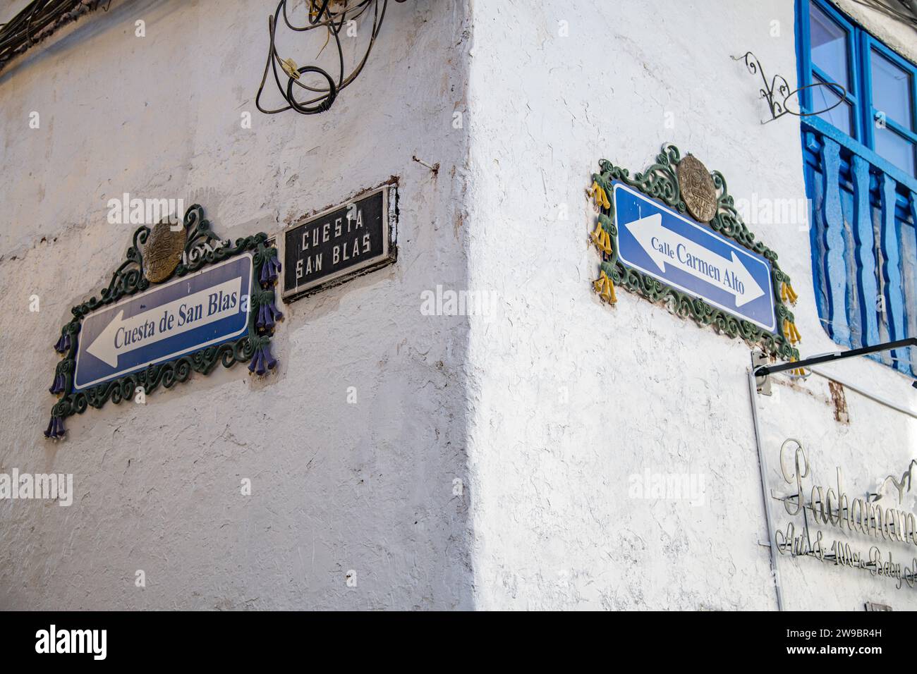 Street signs on the corner of a white building in Cusco, Peru Stock ...