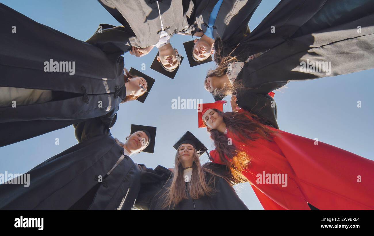 College graduates in a circle stand hugging each other Stock Photo - Alamy