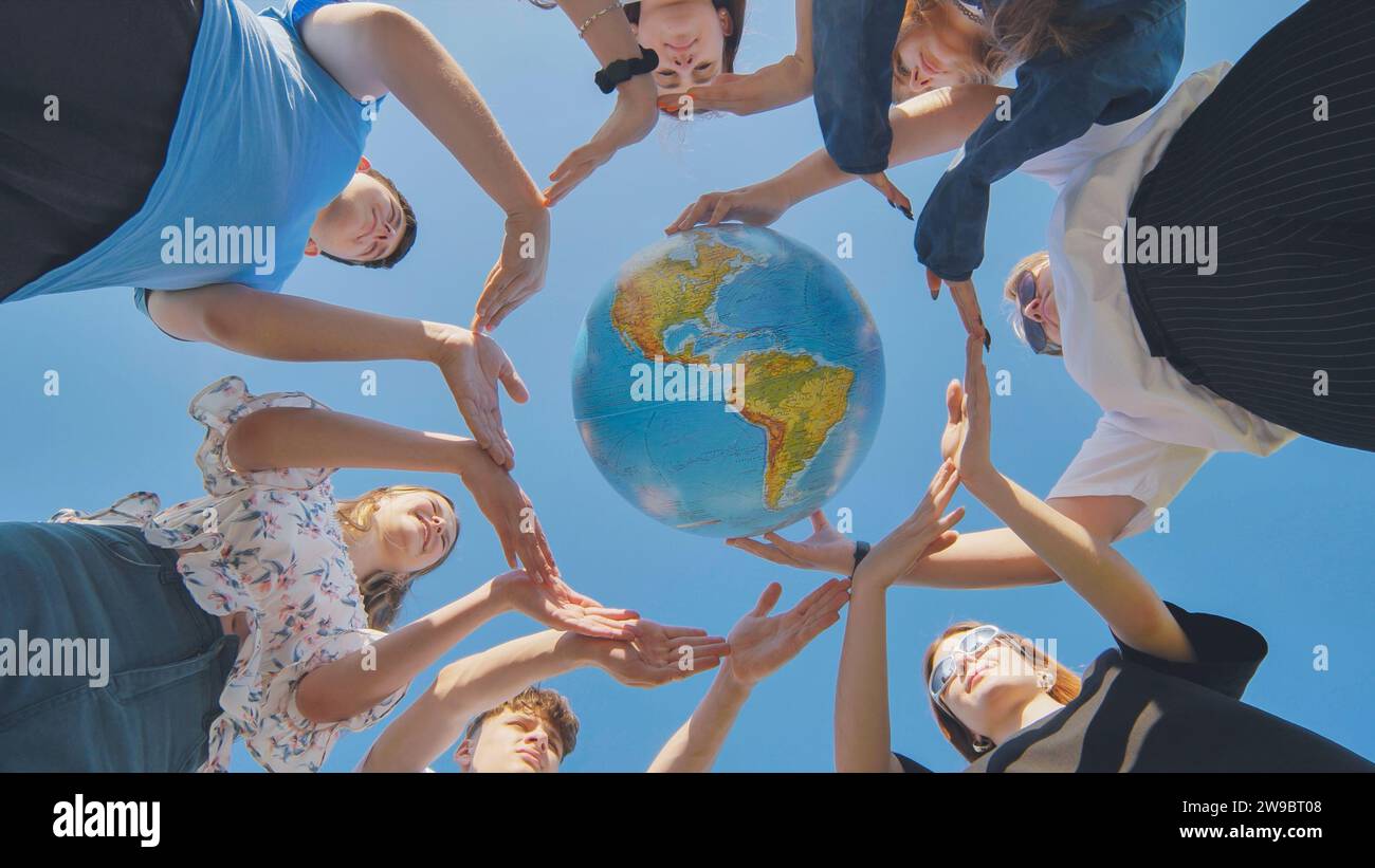 Students make a circle around the globe of the world. The concept of ...