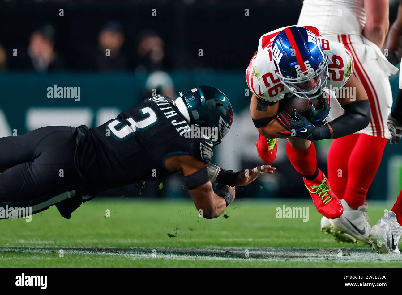New York Giants running back Saquon Barkley (26) is tripped up by ...