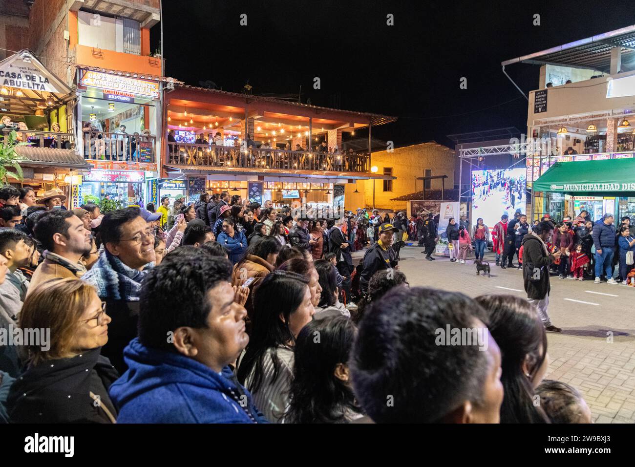A crowd watching a ceremony procession in Aguas Calientes, Peru ...