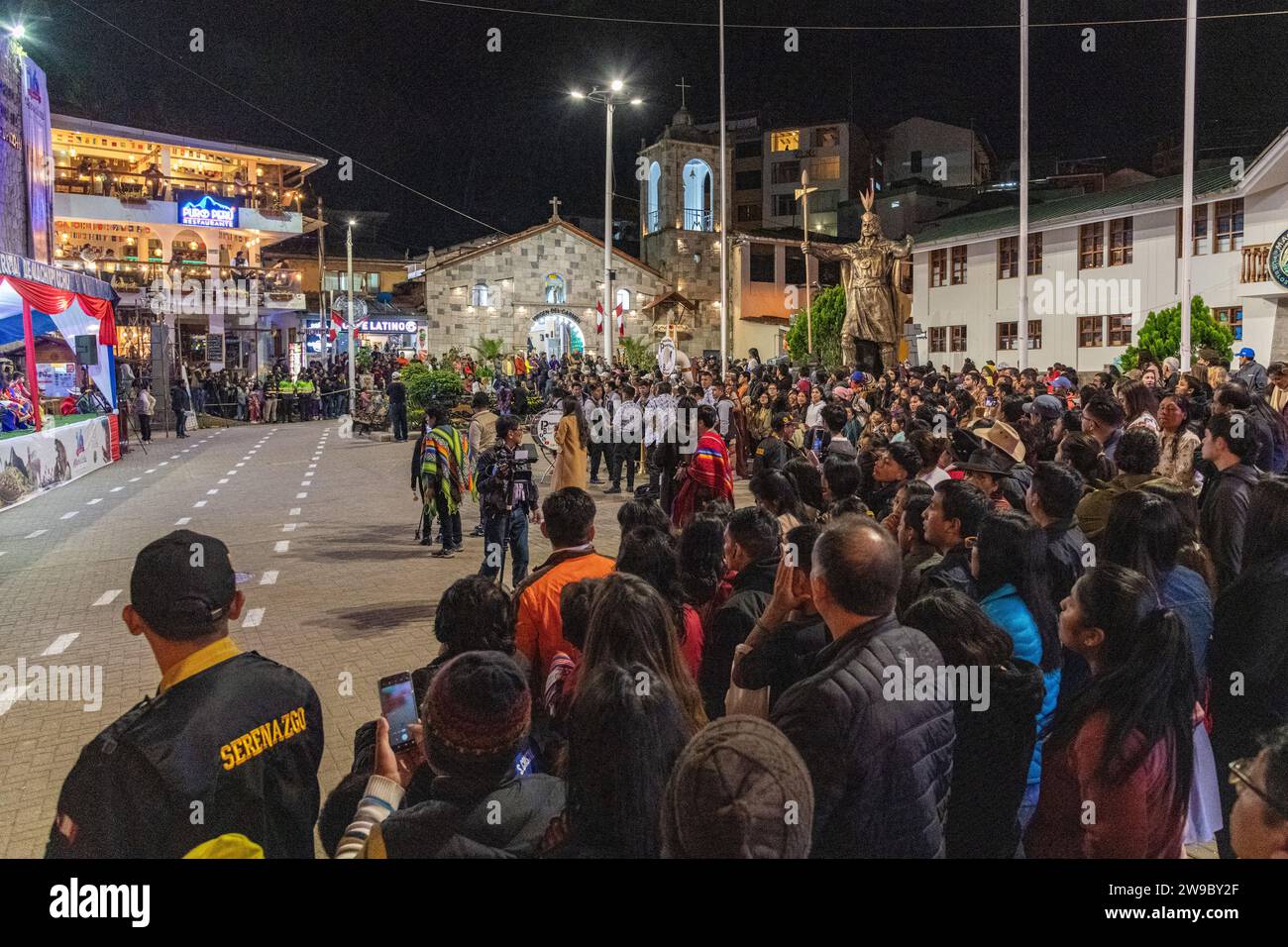 A crowd watching a ceremony procession in Aguas Calientes, Peru ...