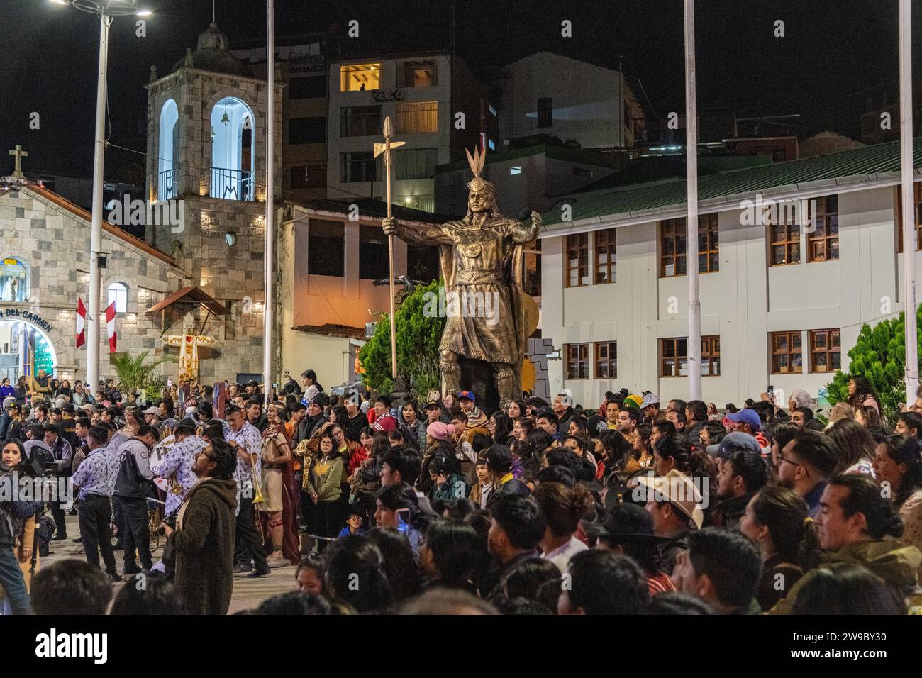 A crowd watching a ceremony procession in Aguas Calientes, Peru ...
