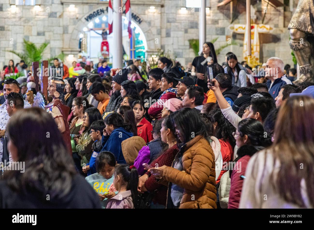 A crowd watching a ceremony procession in Aguas Calientes, Peru ...