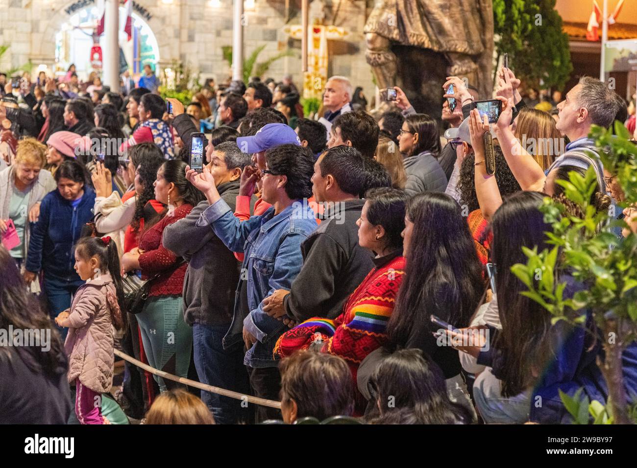 A crowd watching a ceremony procession in Aguas Calientes, Peru ...