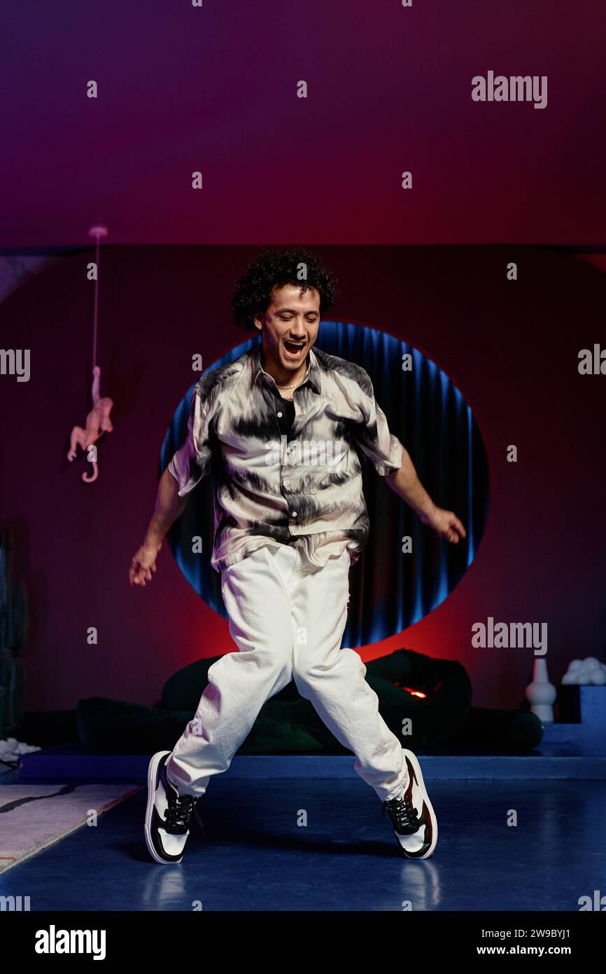 Young cheerful breakdancer standing on tiptoes demonstrating dance ...