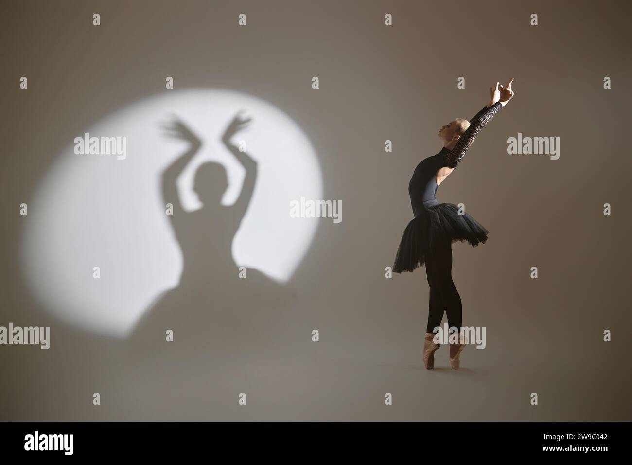 Ballerina posing on tiptoes with her arms raised and back bent back ...