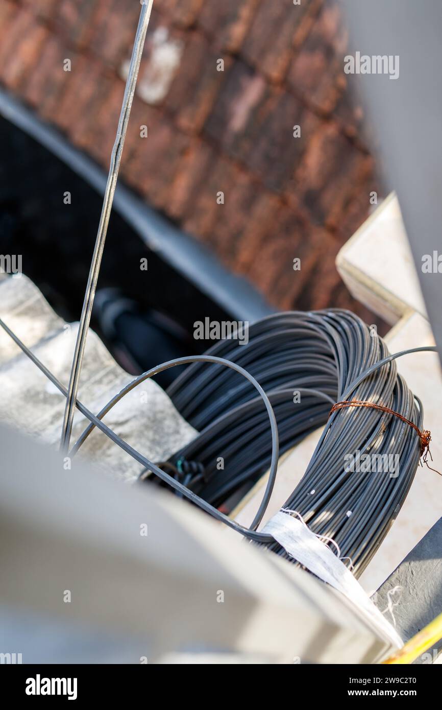 A roll of microfiber cable is tied to the house fence Stock Photo - Alamy