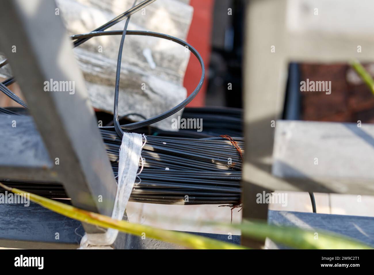 A roll of microfiber cable is tied to the house fence Stock Photo - Alamy