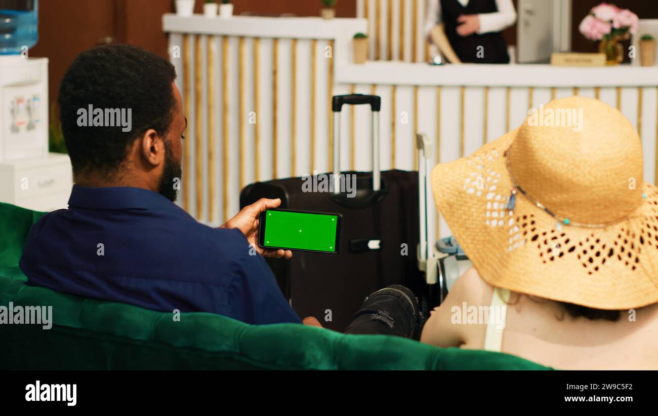 Tourists checking greenscreen on phone, arriving at exotic seaside ...