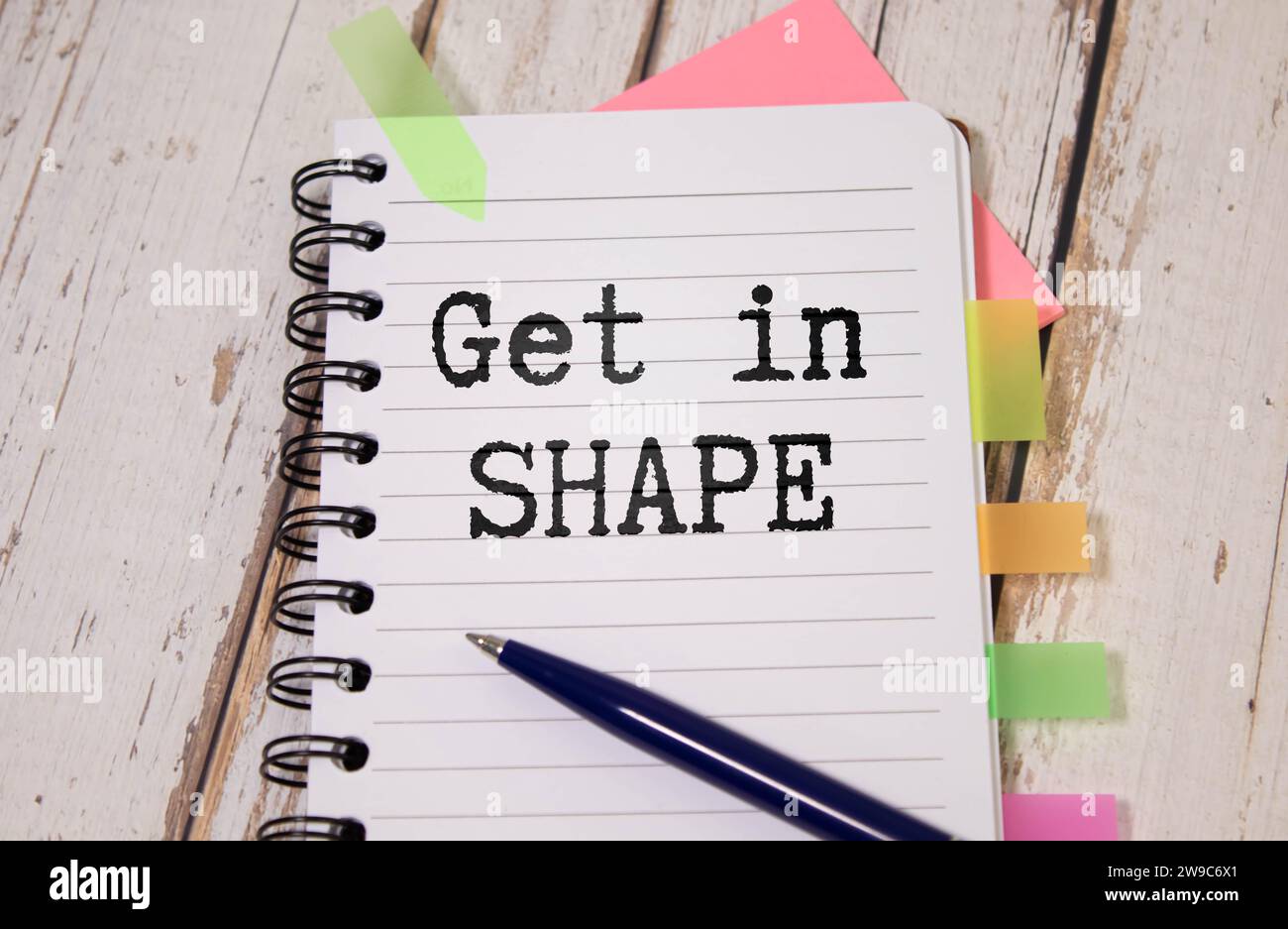 Get in shape - handwriting on notepad with dumbbell, green apple and ...