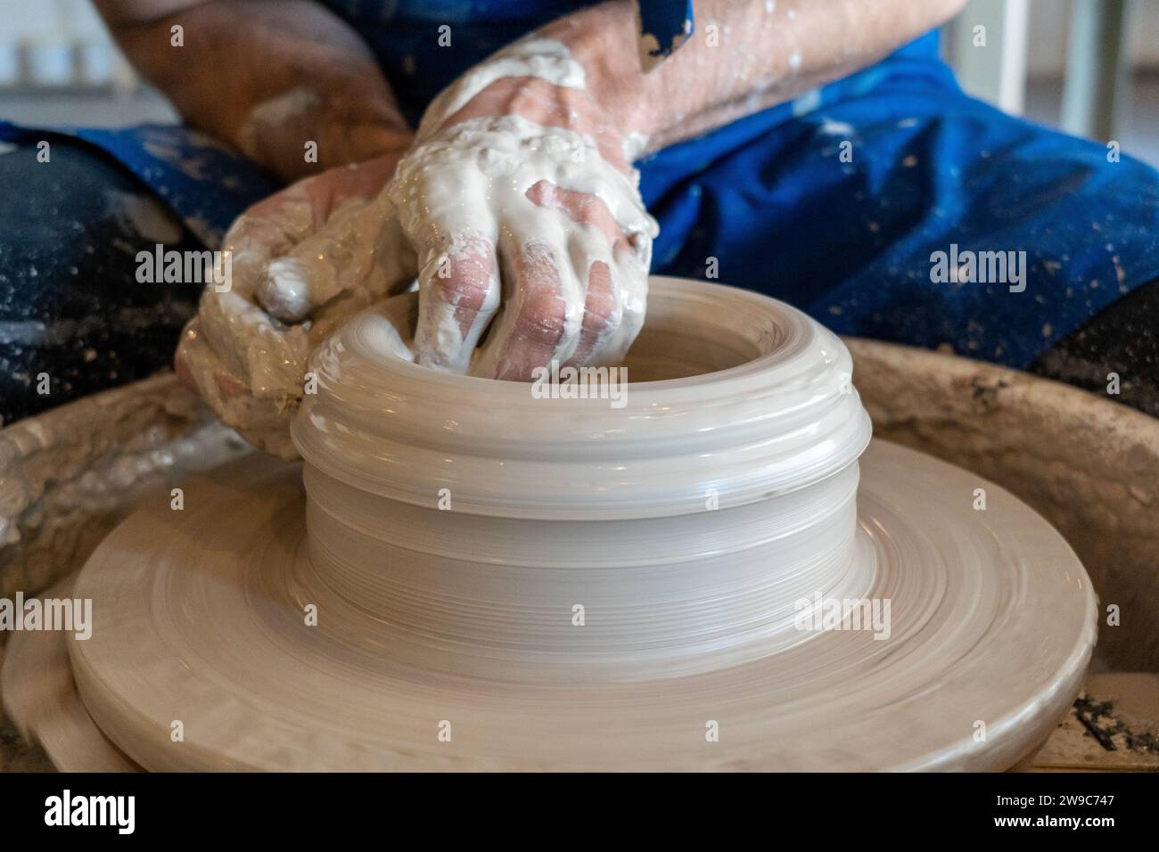 Potter throwing a pot on the wheel in a studio. High quality photo ...