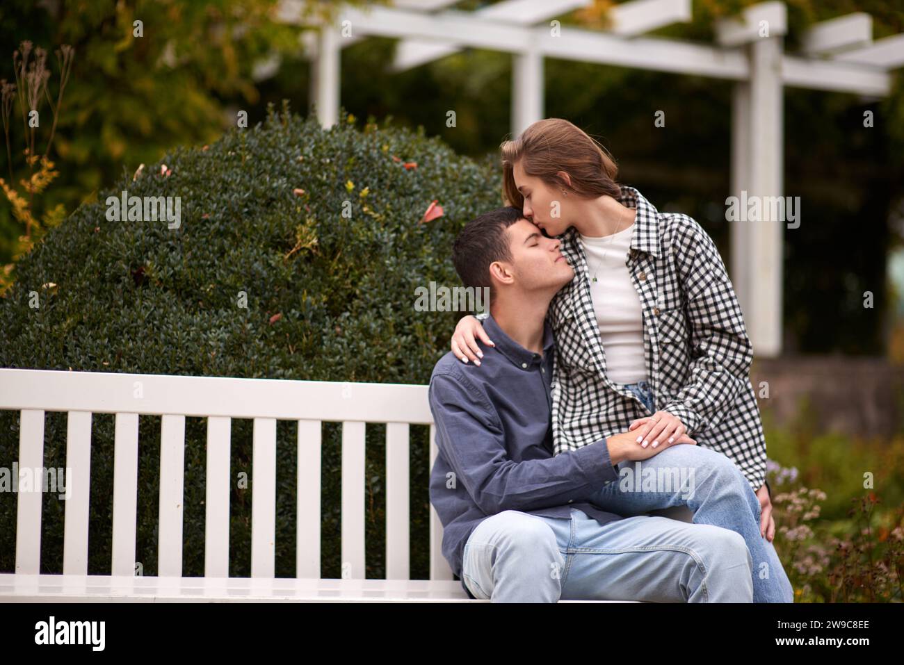 Autumn Romance: Young Couple Embracing and Kissing on Park Bench. Young ...